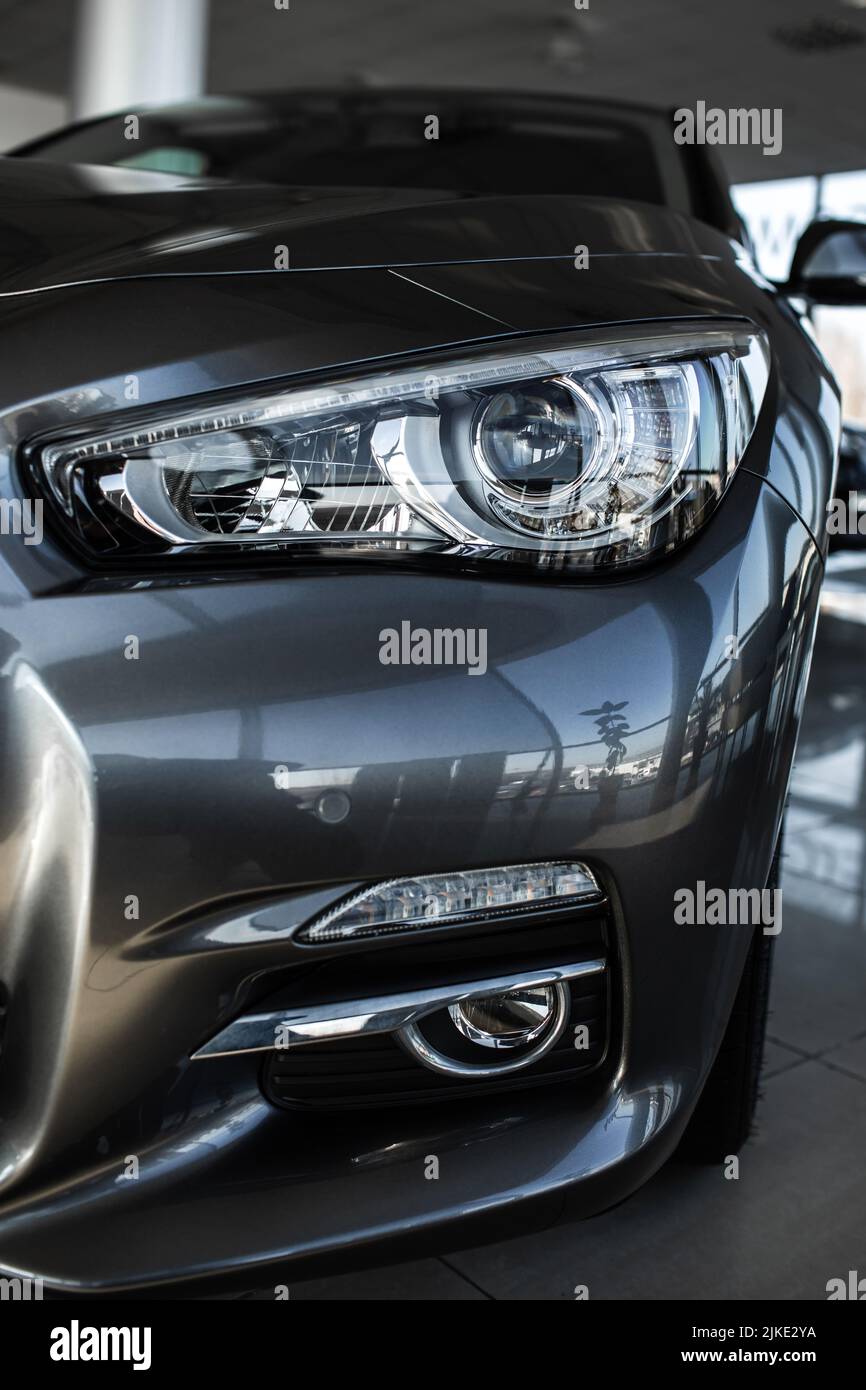 close up of modern headlights on luxury silver new car in automobile ...