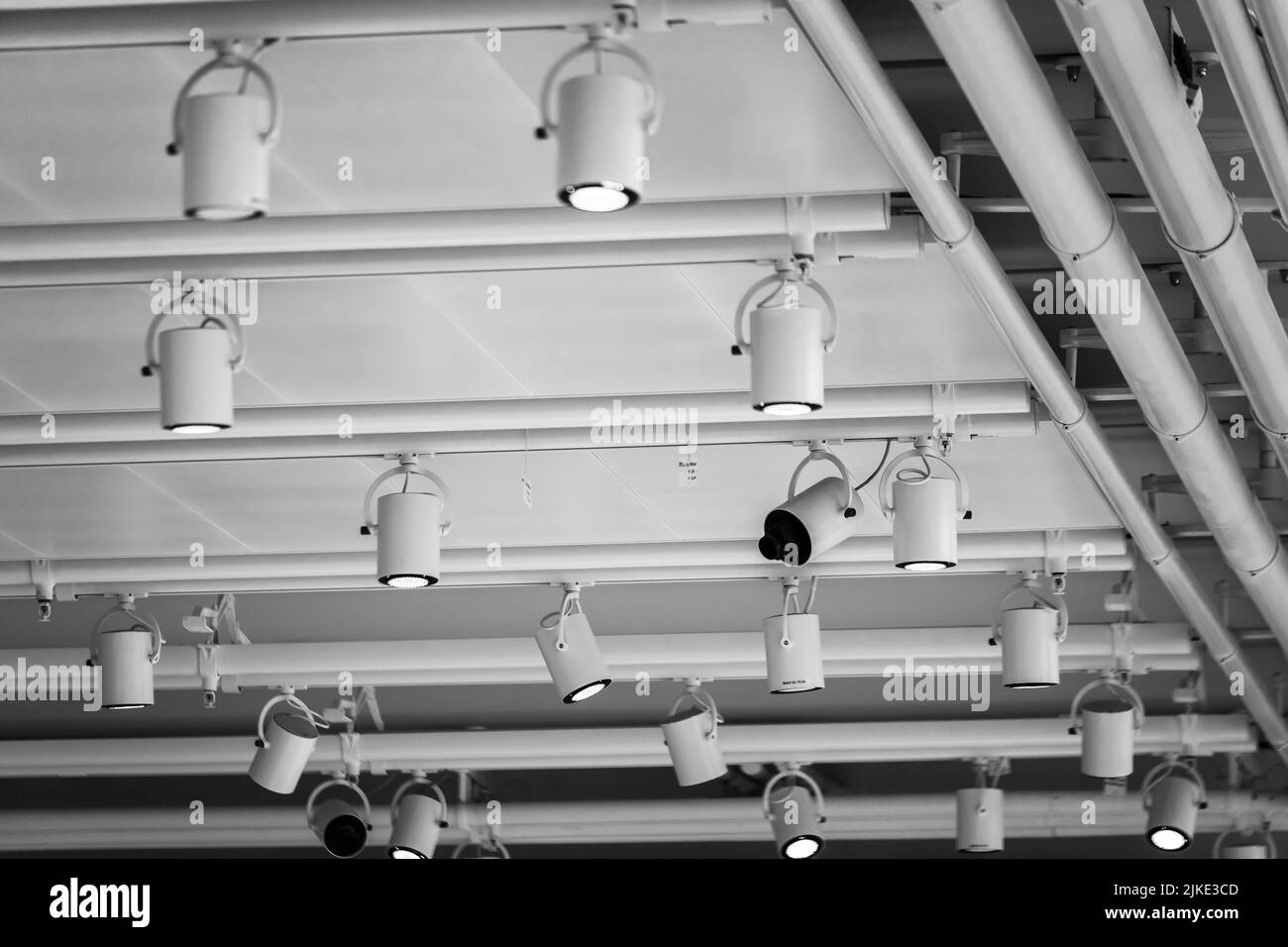 Modern lamps near pipes on ceiling Stock Photo - Alamy