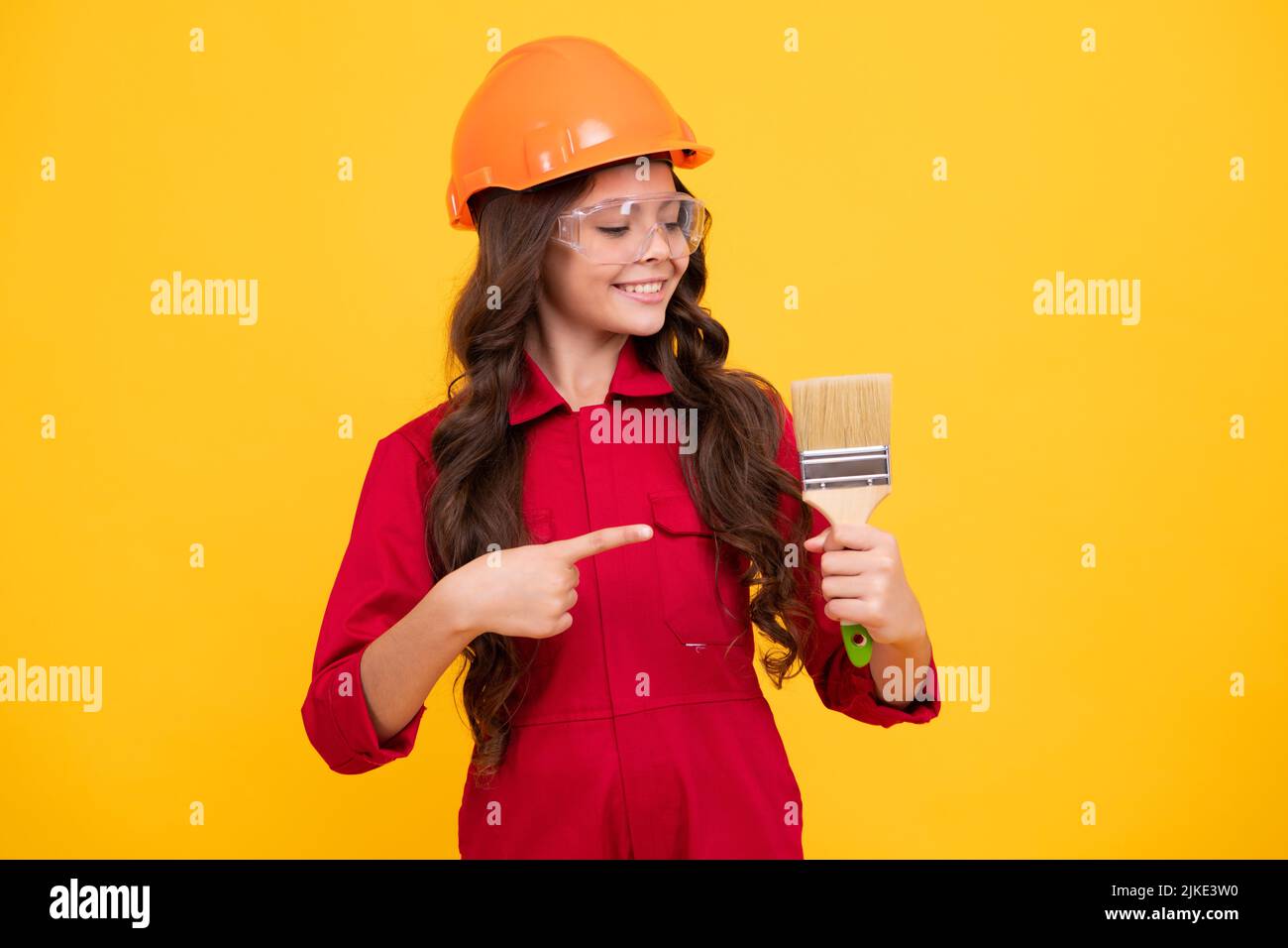 Painter in workshop. Renovation and repair. Teen girl in helmet with ...