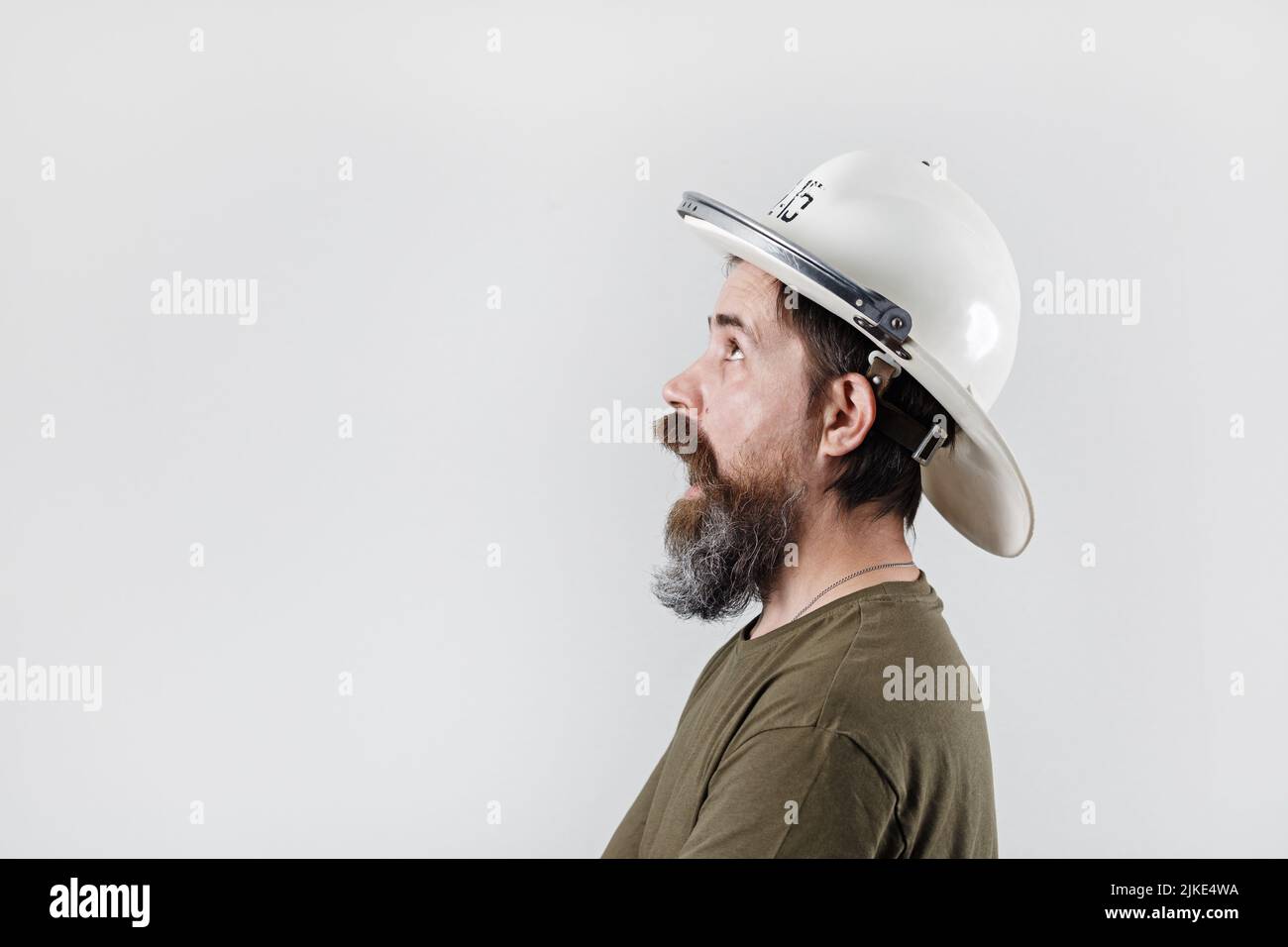 Fireman with open mouth. Crazy bearded man in a fire helmet. Profile ...