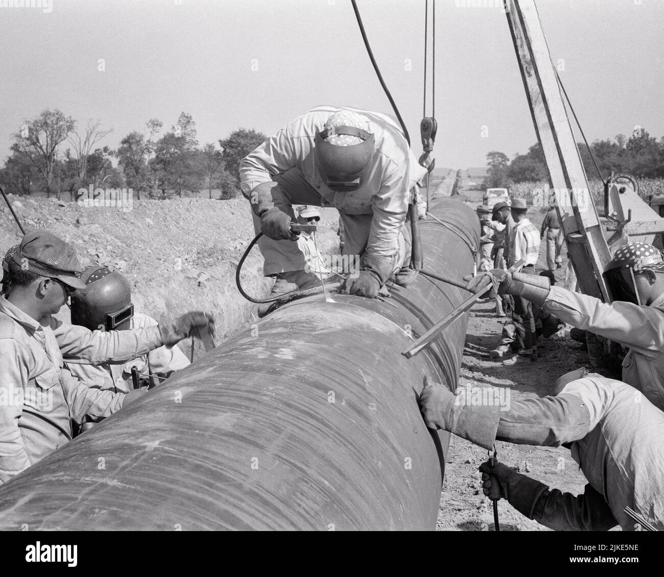 1950s CREW OF CONSTRUCTION MEN ELECTRIC ARC WELDERS JOINING PIPE ...