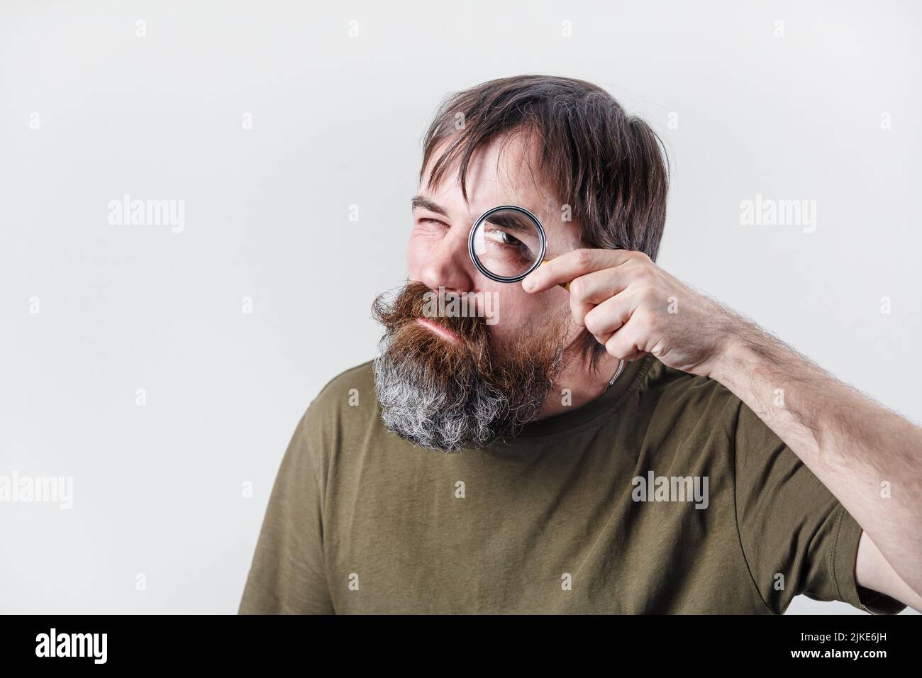 Curious bearded man see through magnifying glass. Science and curiosity ...