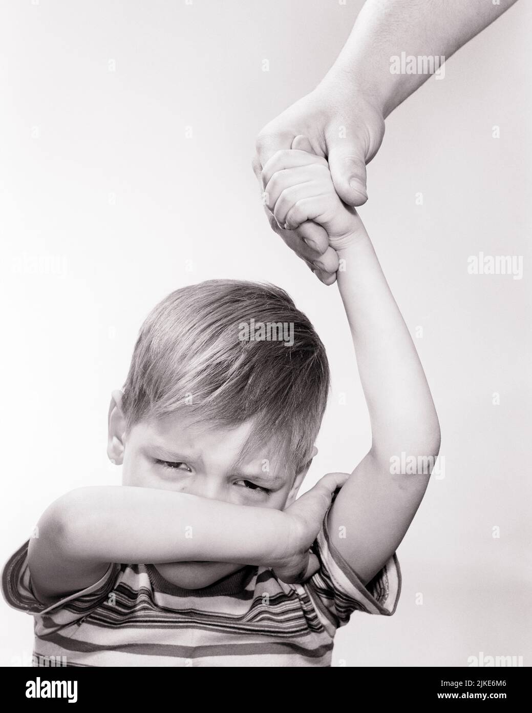 1960s CRYING LITTLE BOY COVERING HIS FACE WITH ONE ARM THE OTHER RAISED ...