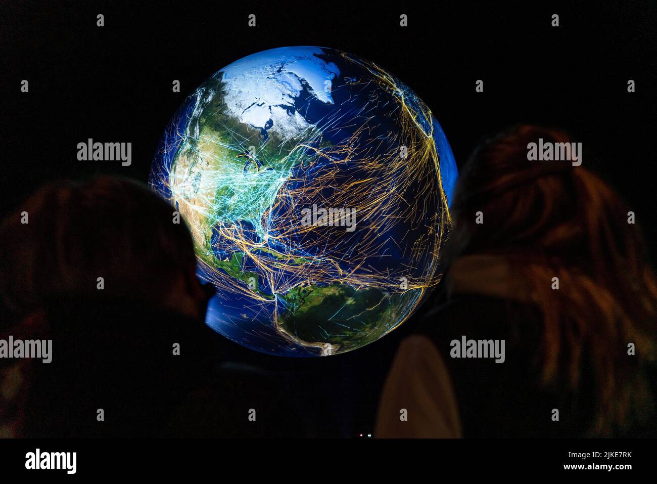 People looking up at a glowing 3d render of the Earth Stock Photo - Alamy