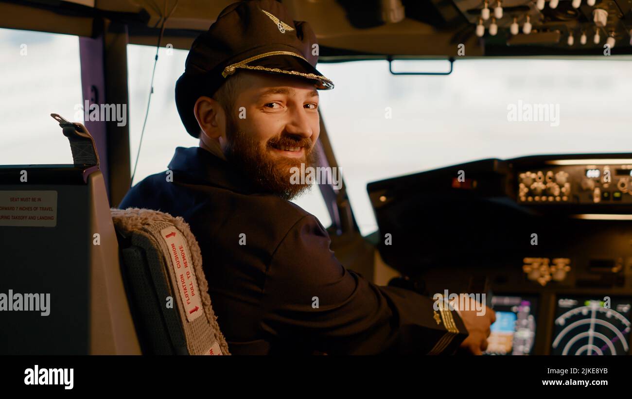 Portrait of airline captain sitting in pilot seat to fly airplane using ...