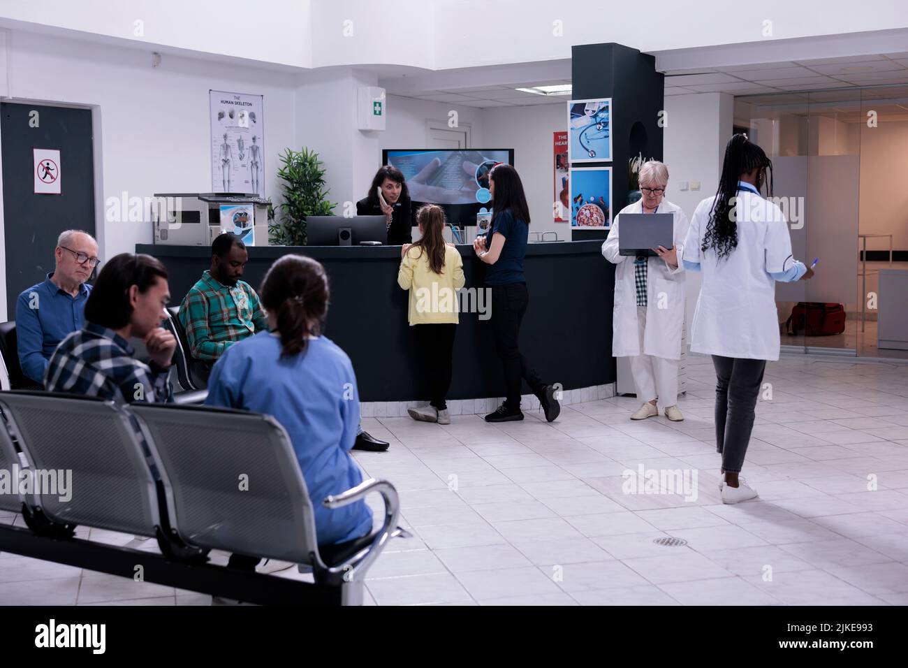 Front desk receptionist talking with young girl patient registering for ...