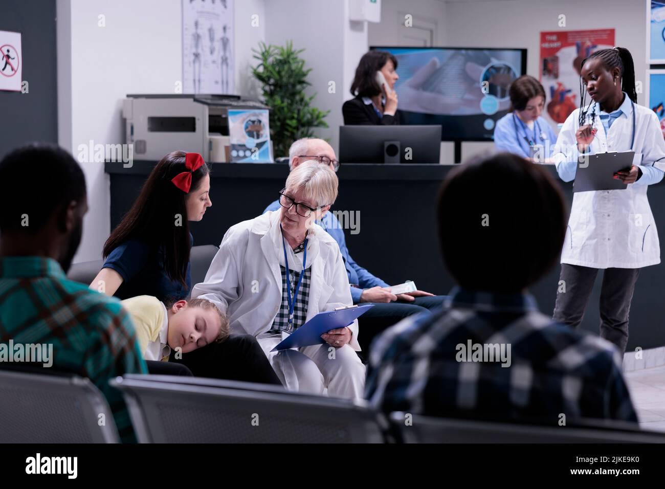 Senior medical doctor with stethoscope completing form for woman and ...
