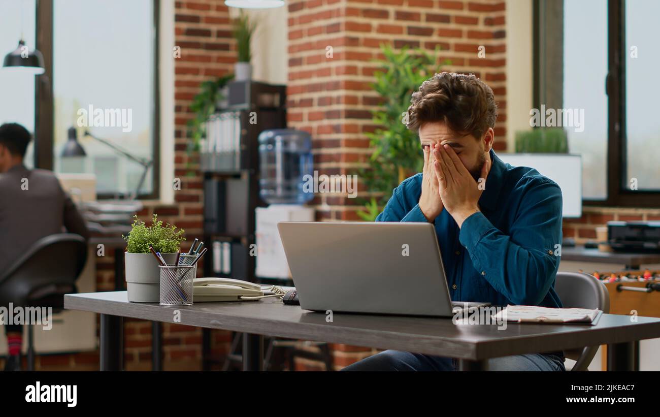 Tired overworked employee working in tension to plan project before ...