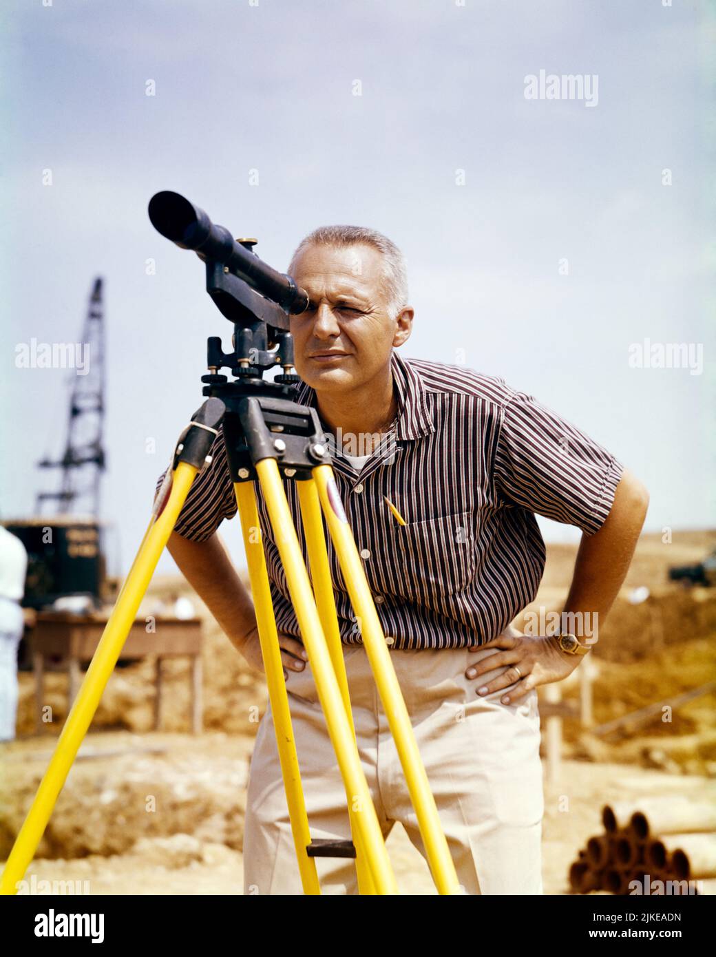 1960s MAN PROJECT MANAGER SURVEYOR ON CONSTRUCTION SITE USING TRIPOD ...