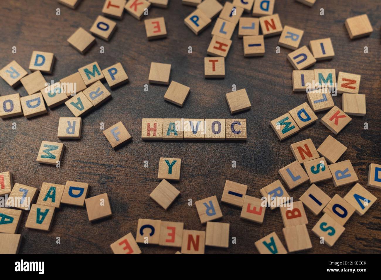 Word play. Square colorful wooden letters creating the word HAVOC ...