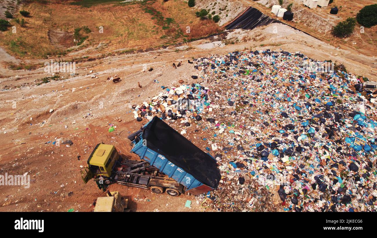 Truck unloading tons of garbage on sandy waste dump. Waste pollution ...