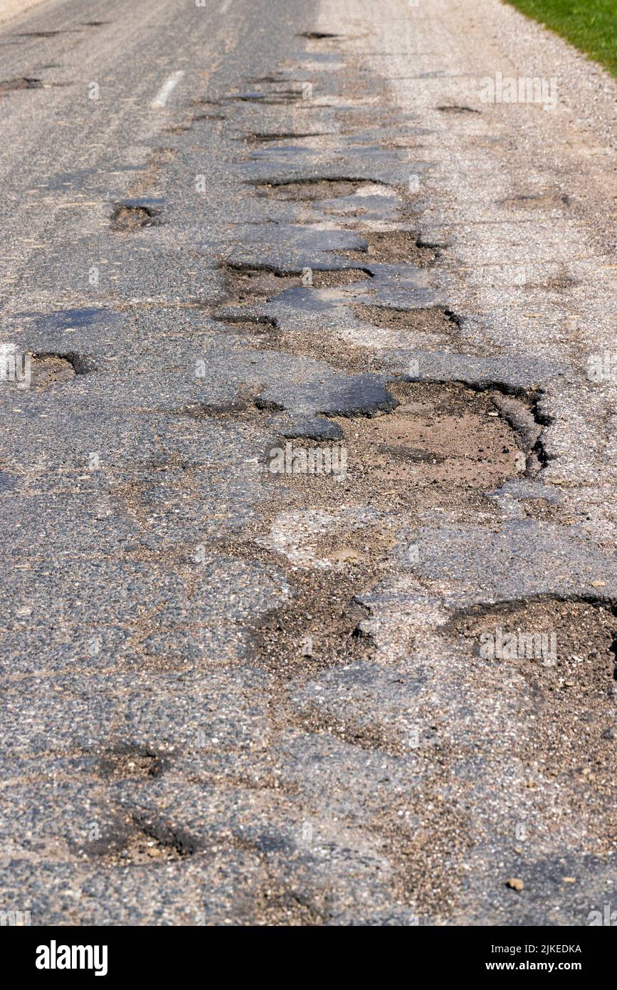 poor paved road with a lot of holes and potholes, poor transport ...