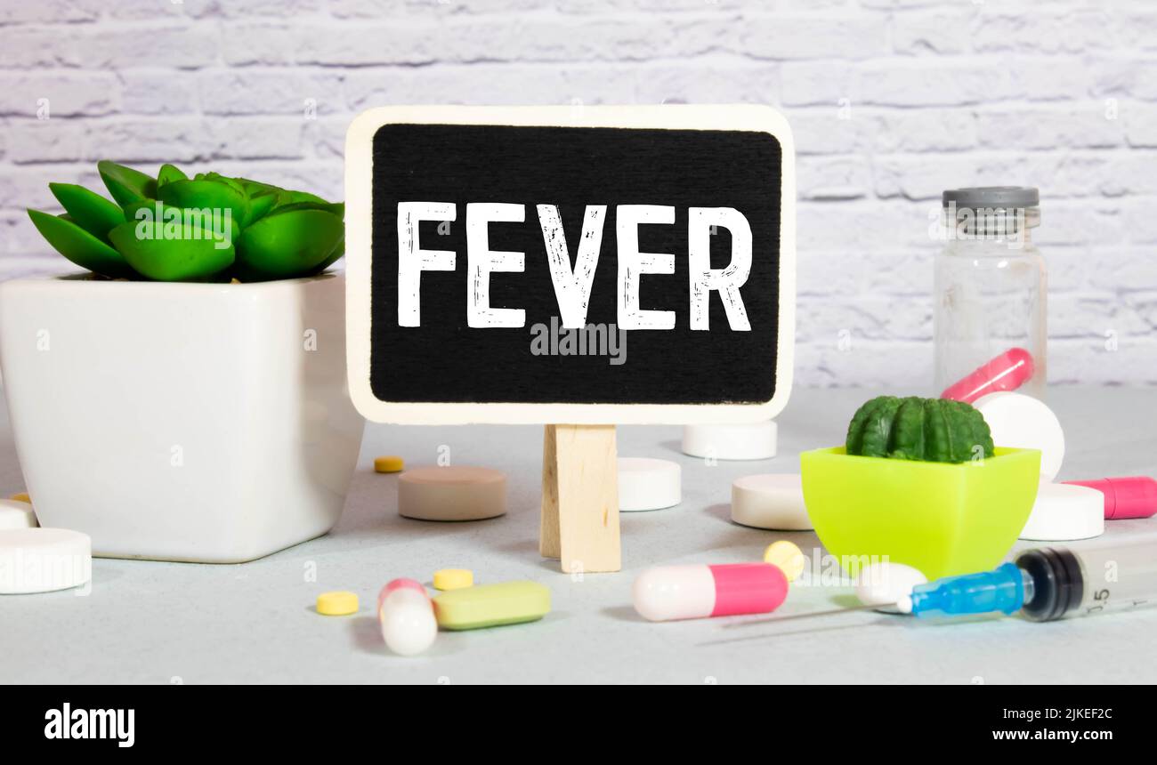 Fever, word cube with background. medical concept Stock Photo - Alamy