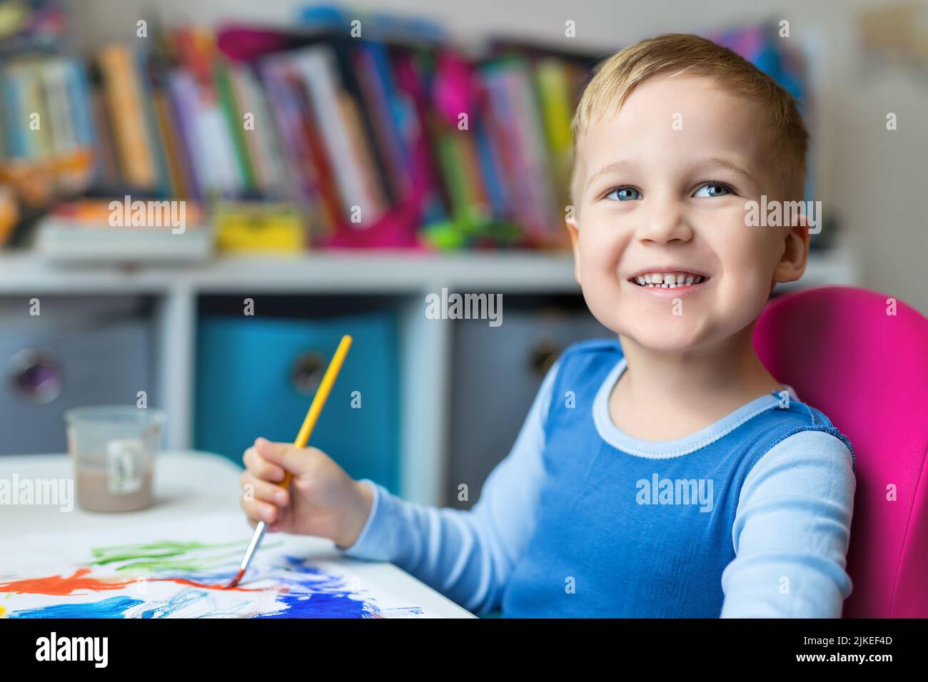 Portrait of cute little blond kid boy enjoy have fun painting with ...
