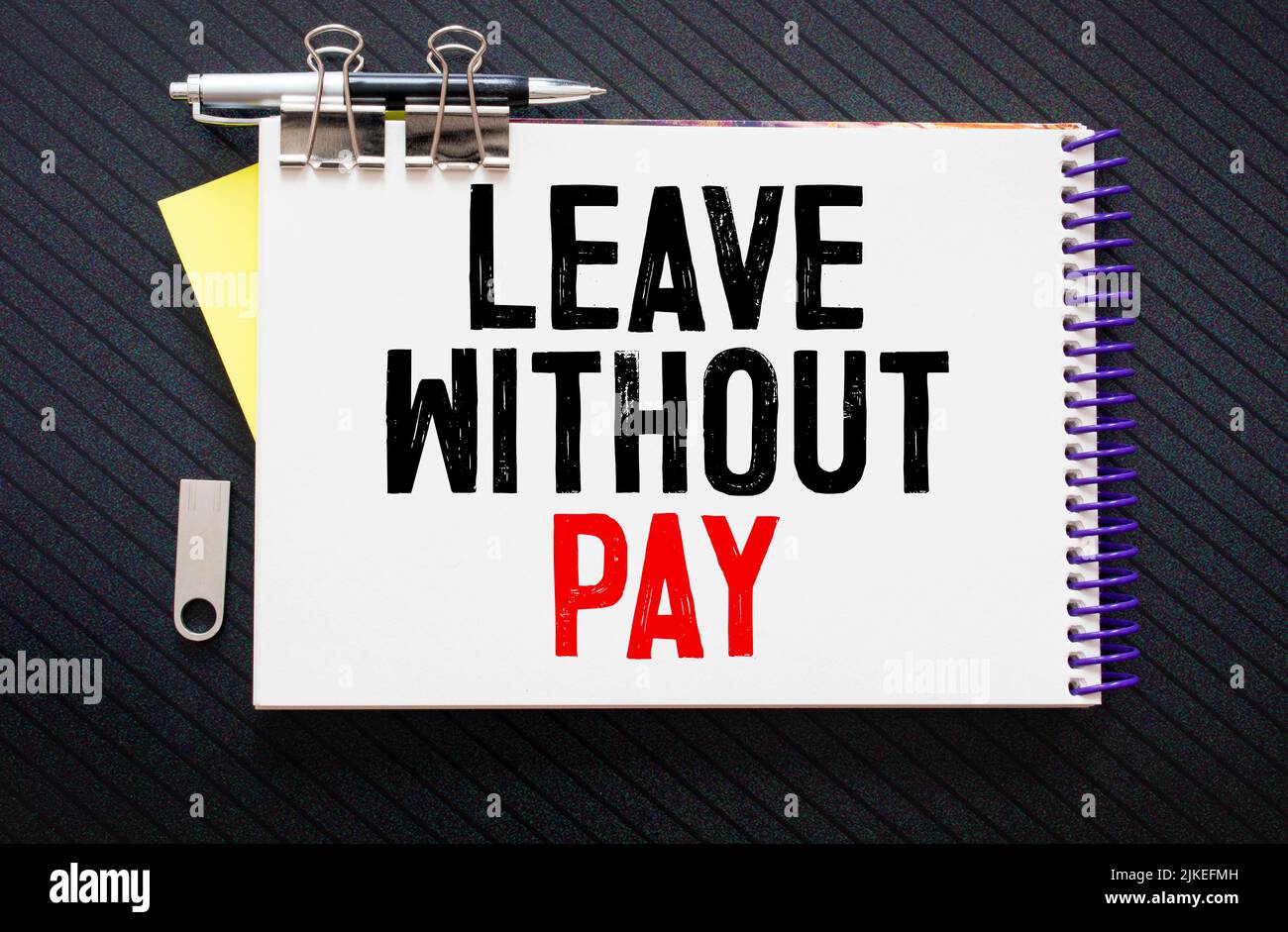 Closeup on businessman holding a card with text LEAVE WITHOUT PAY ...