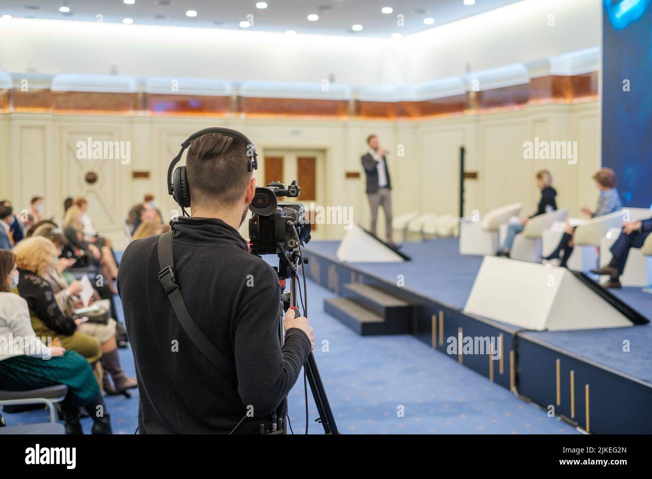 Cameraman shooting speakers during business conference Stock Photo - Alamy