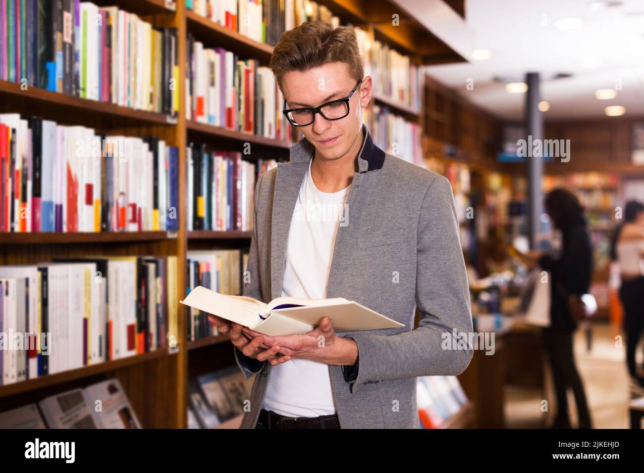 Student browsing textbooks in library Stock Photo - Alamy