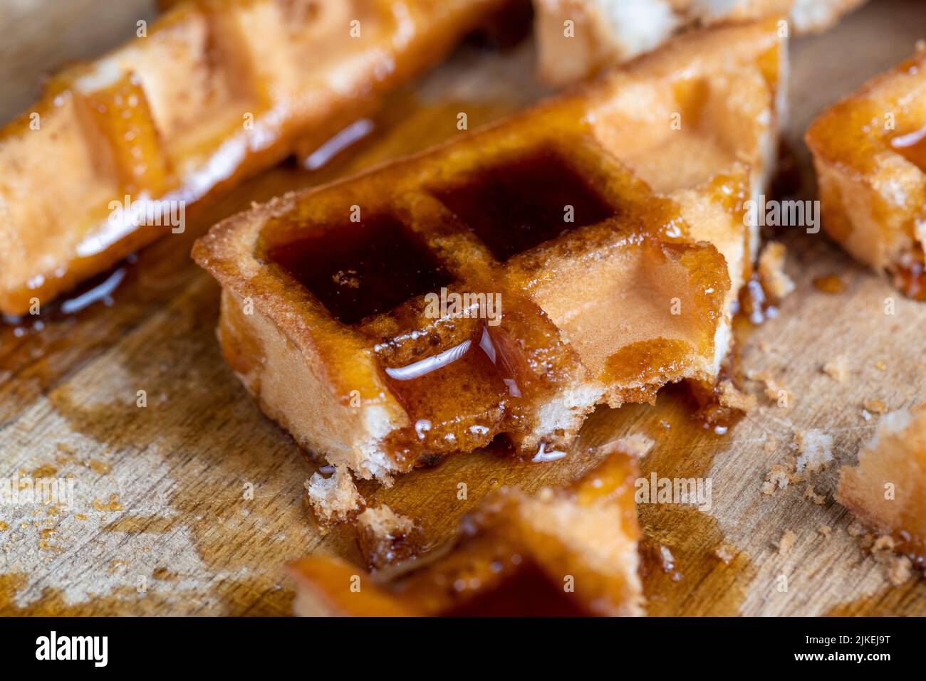 square sweet soft waffles in bee honey , a traditional European dessert ...