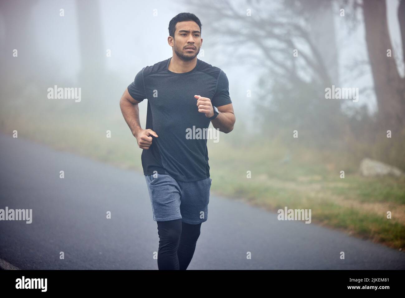 A mighty warrior has appeared from the mist. a sporty young man running ...