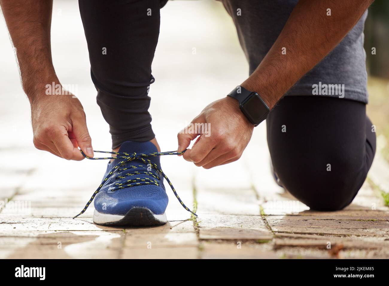 Come on, lets go run. Closeup shot of an unrecognisable man tying his ...