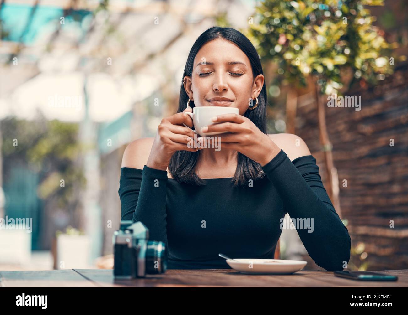 Beautiful, happy and relaxed woman smelling fresh coffee and enjoying a ...