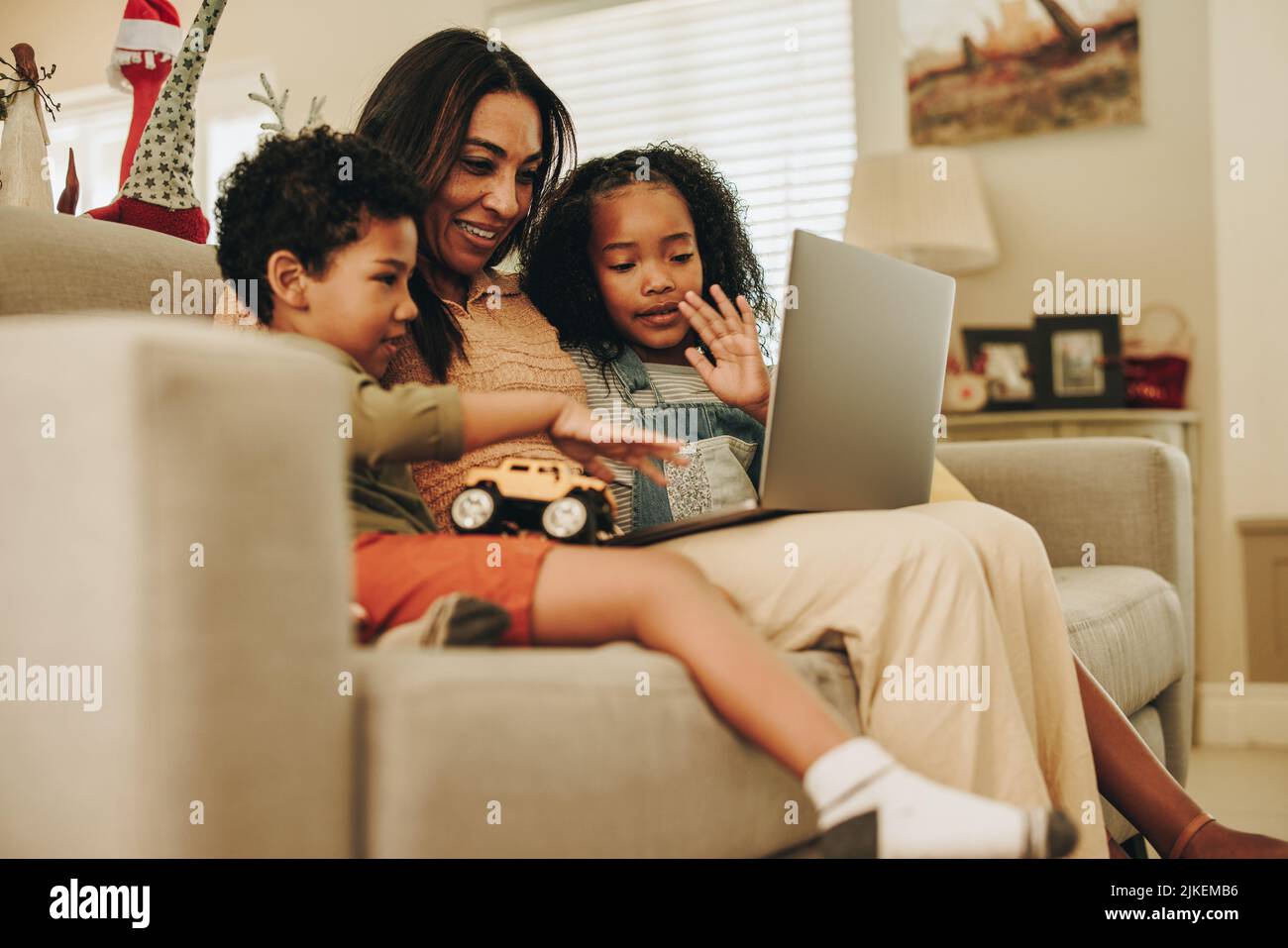 Happy ethnic family having a video call on a laptop. Cheerful family of ...