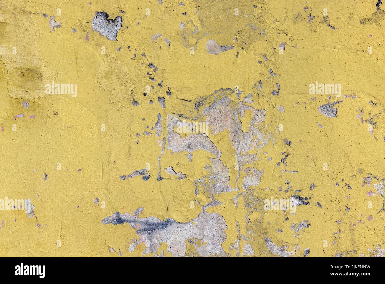 Damaged yellow plaster of a concrete wall, part of a damaged building ...