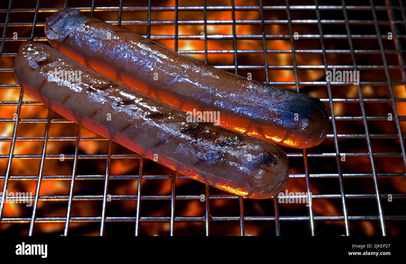 Pair of hot dogs that are cooking over a fire Stock Photo - Alamy