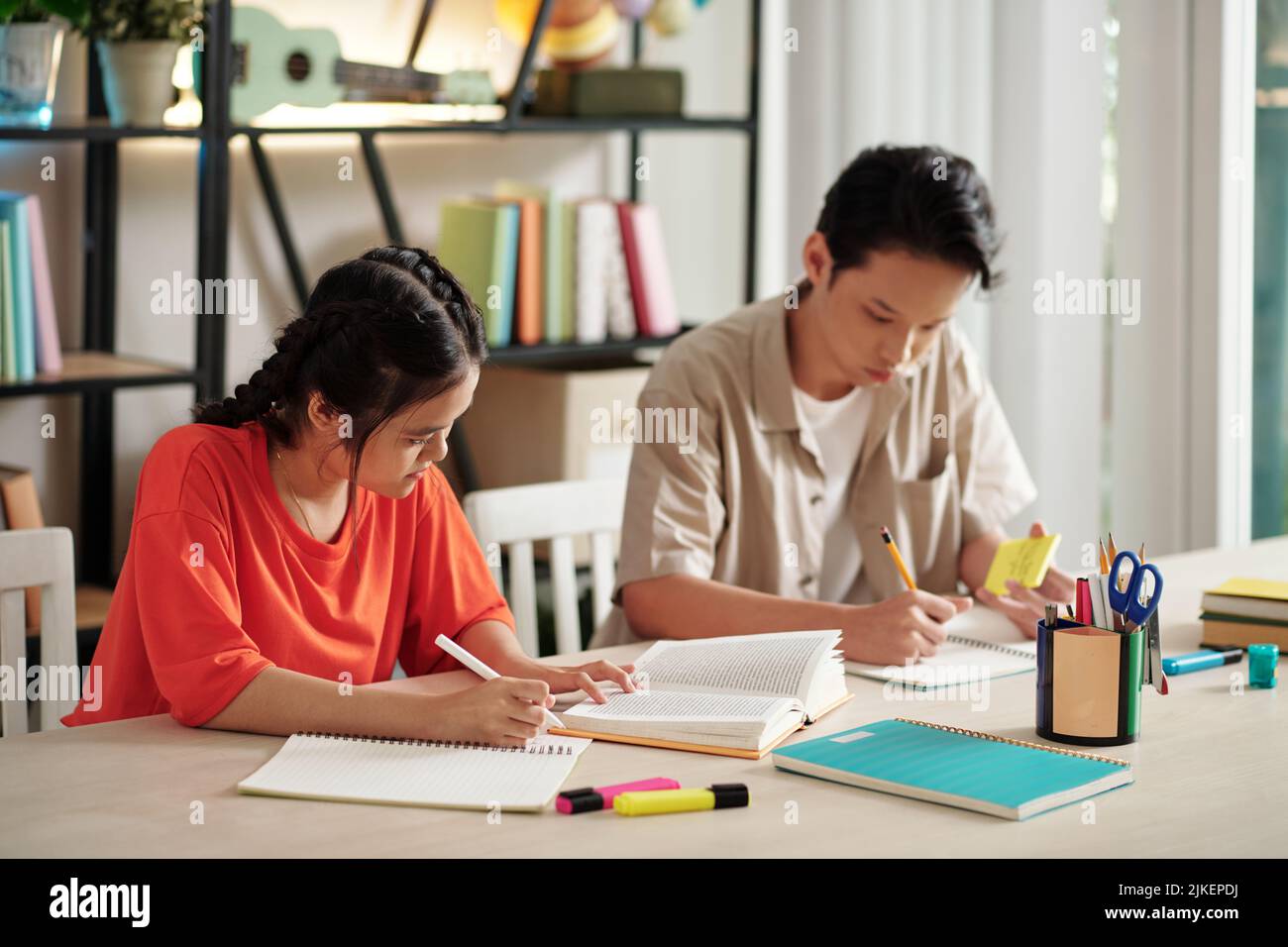 Schoolchildren studying in class, revising for exam and writing on ...