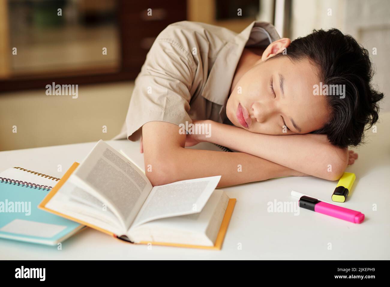 Exhausted teenage boy sleeping after doing homework for tomorrow class ...