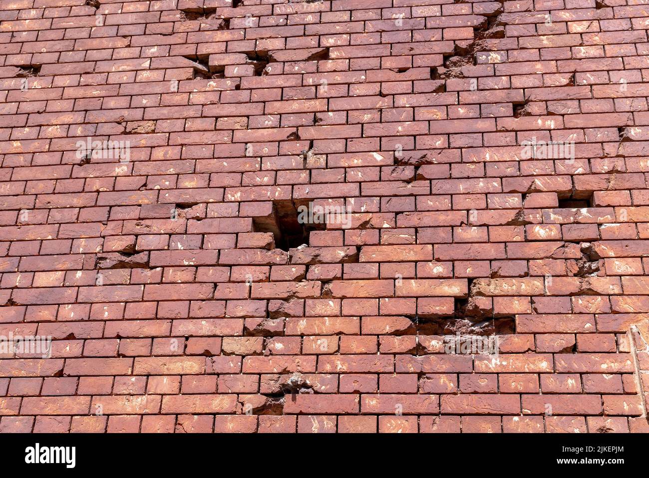 An old brick wall with various damages, the wall is old and made of ...
