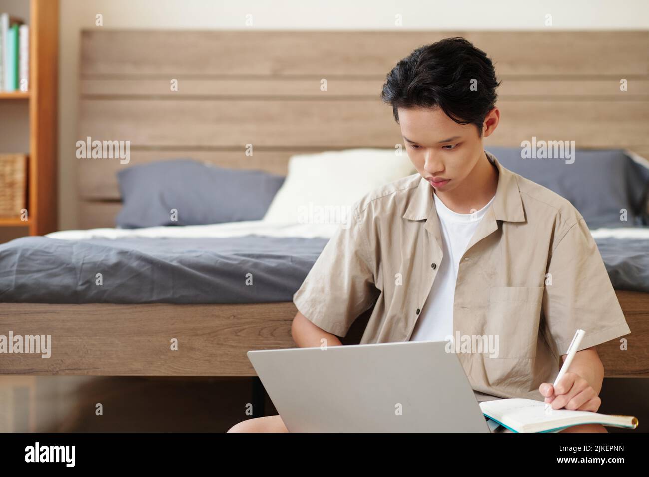 Concentrated teenage boy watching educational video on laptop and ...