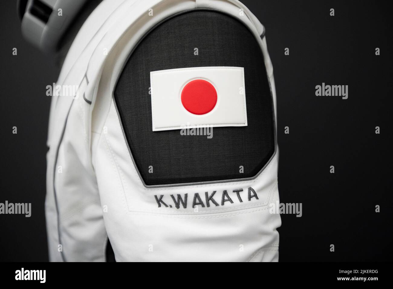 A SpaceX launch and entry suit bears a Japanese flag, and the name of ...