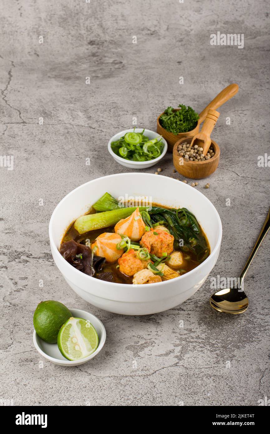 Tom Yam Spicy Thai soup with fish meatball, seafood, coconut milk ...