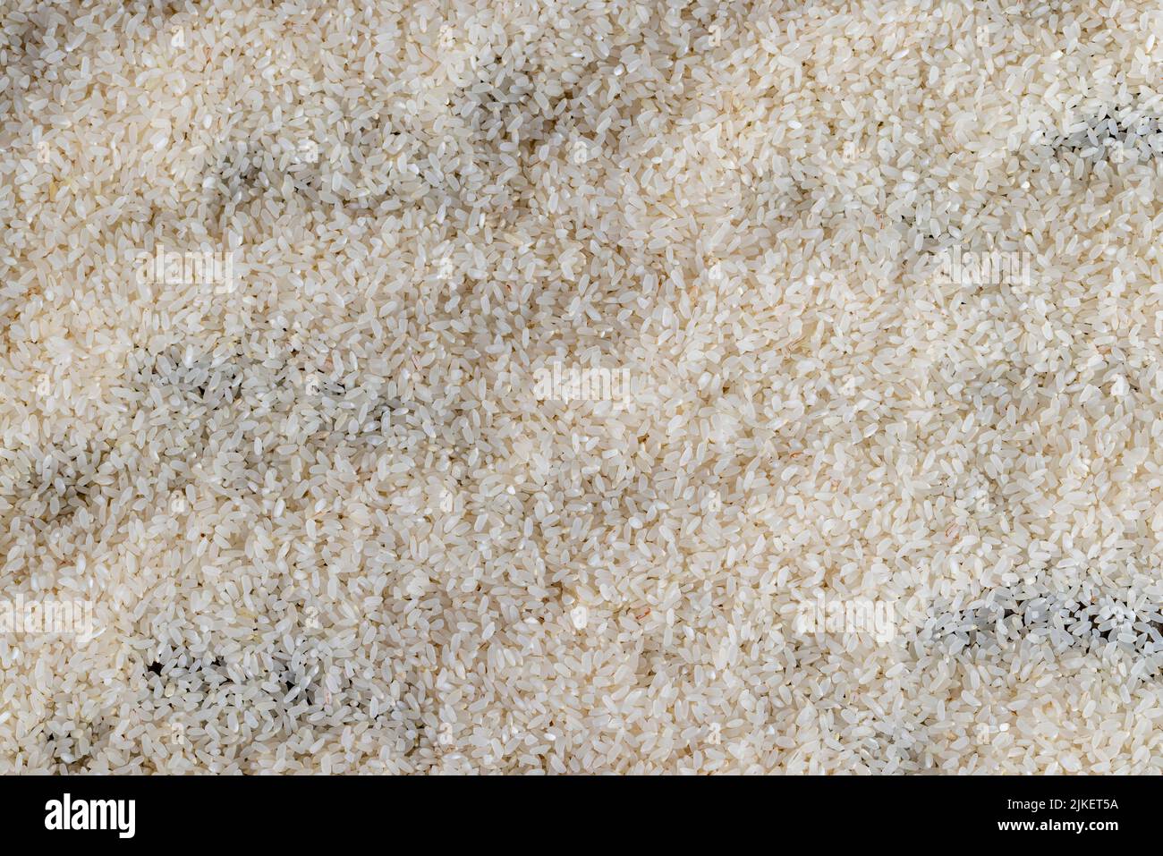 a pile of scattered white rice on the kitchen table, white uncooked ...