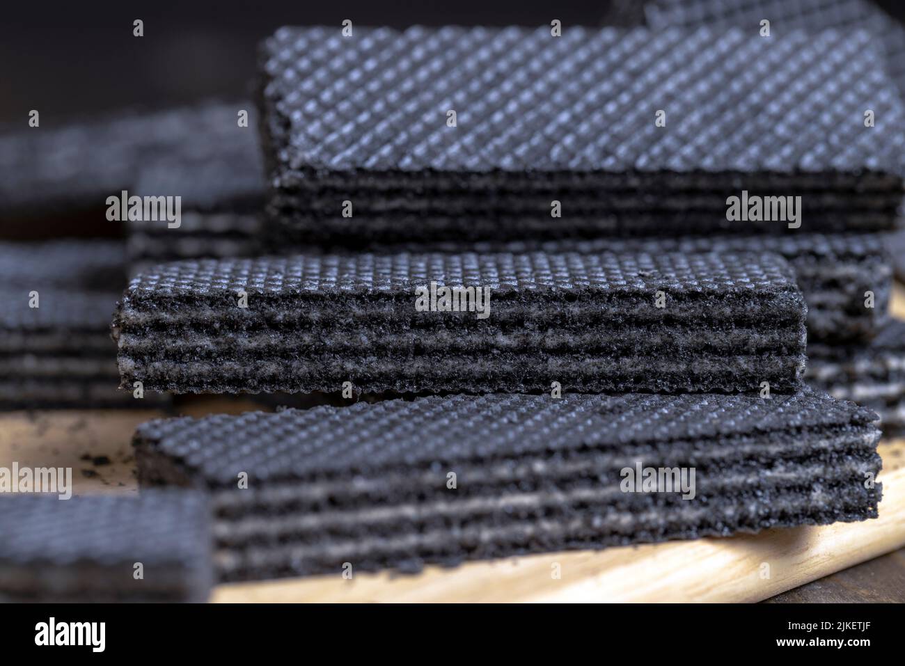 sweet dessert black waffles with creamy filling inside, laid out on a ...