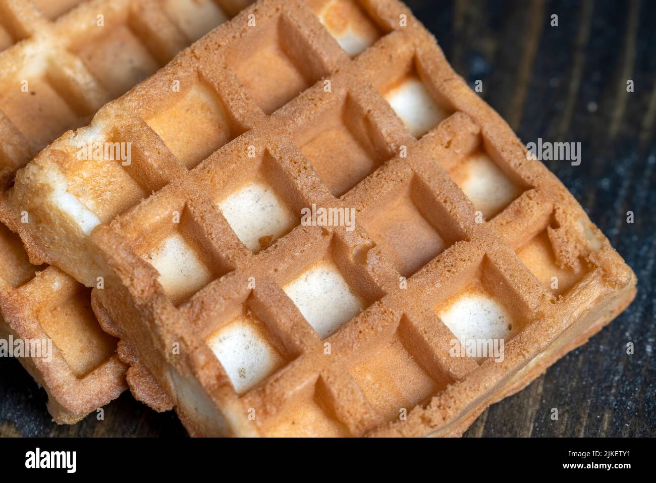 square sweet soft waffles on the table, a traditional European dessert ...