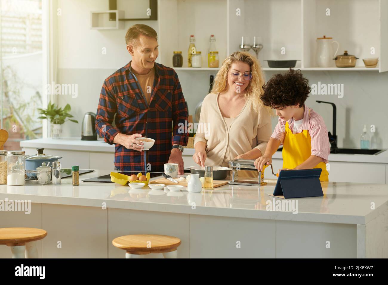 Happy family making noodles at home for dinner Stock Photo - Alamy