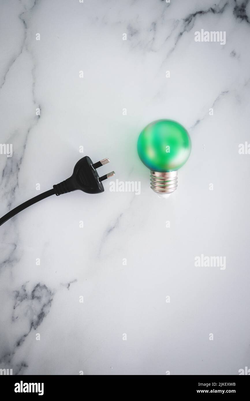 concept of clean green energy, electric plug next to green lightbulb ...