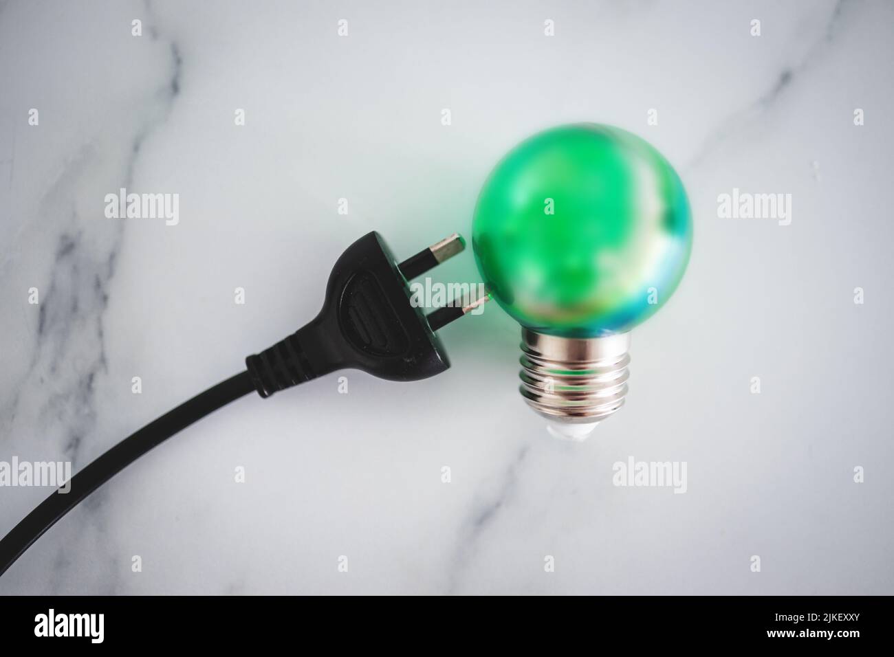 concept of clean green energy, electric plug next to green lightbulb ...