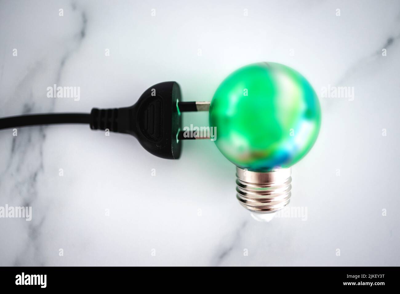 concept of clean green energy, electric plug next to green lightbulb ...