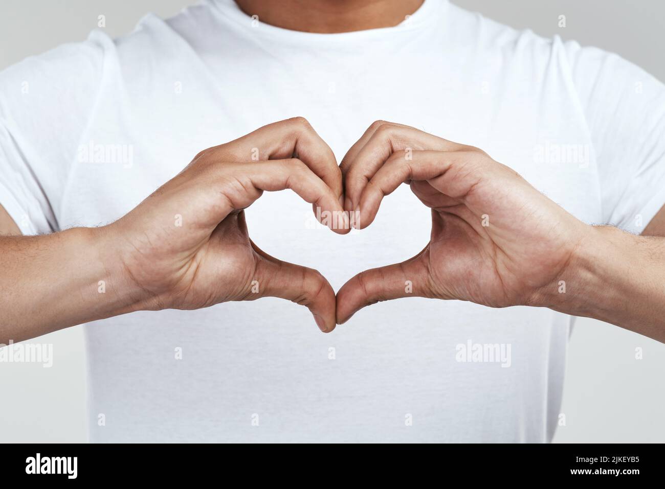 Put some heart into it. an unrecognizable man forming a heart shape ...