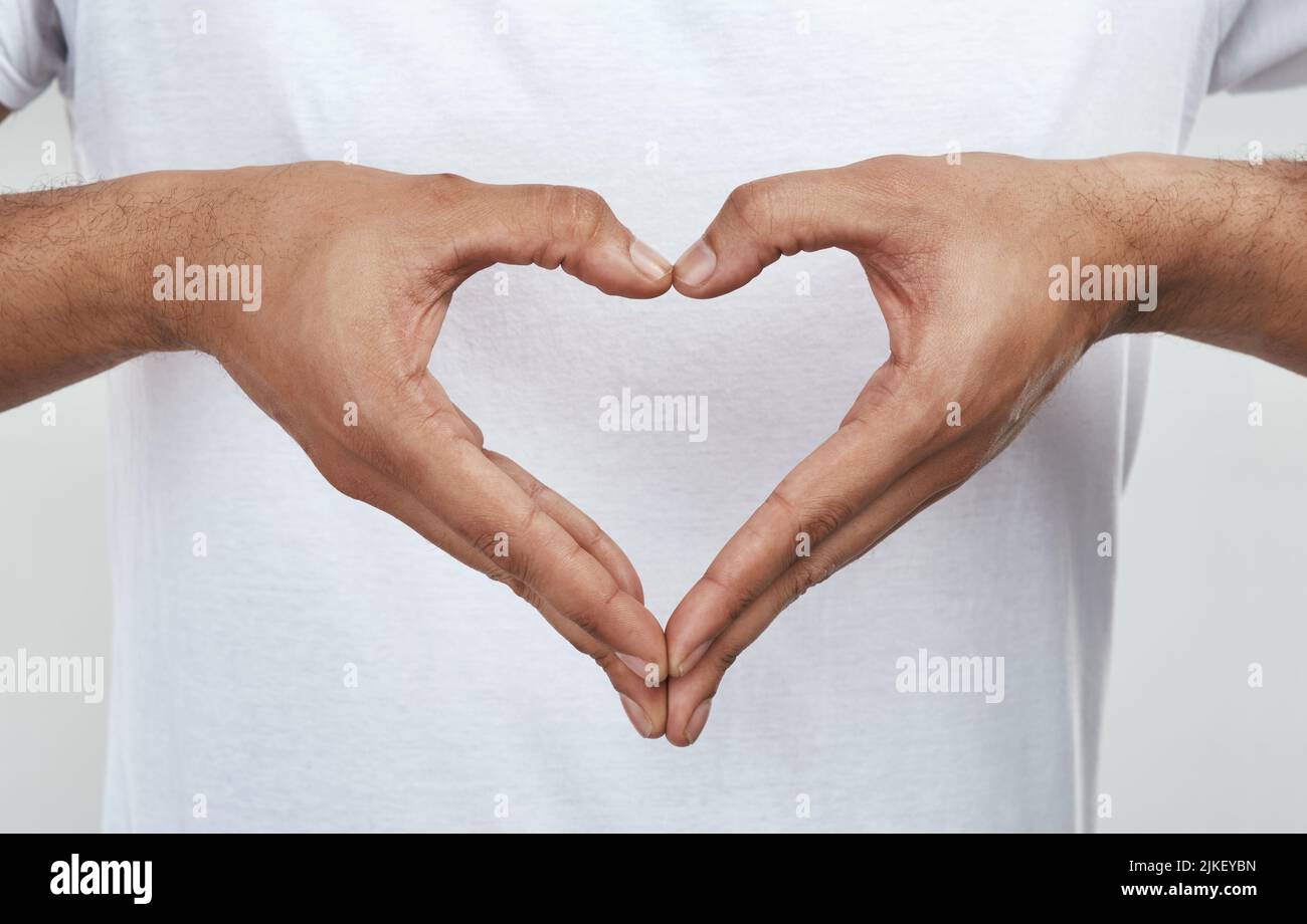 The heart never lies. an unrecognizable man forming a heart shape with ...
