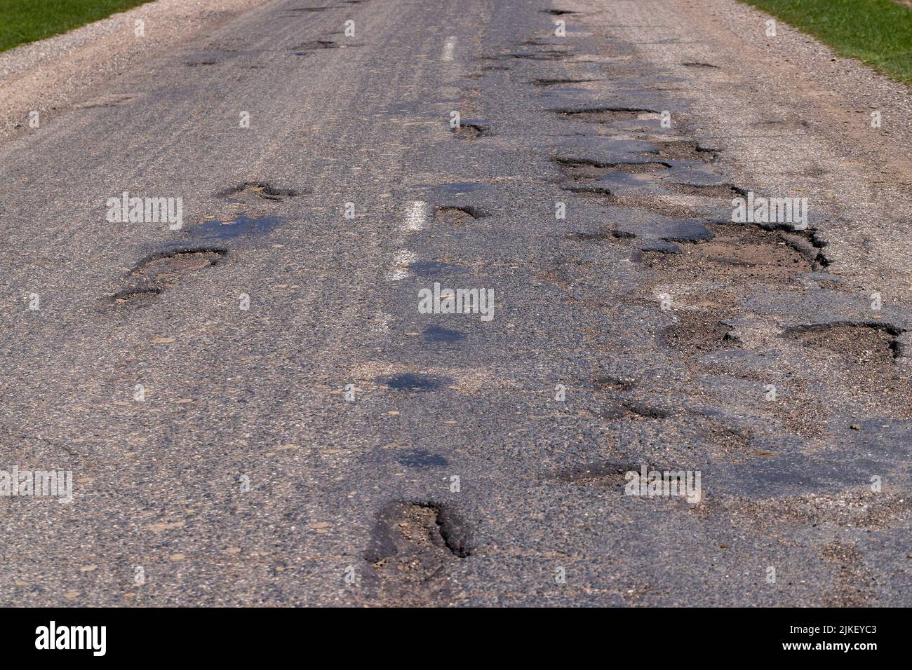 poor paved road with a lot of holes and potholes, poor transport ...