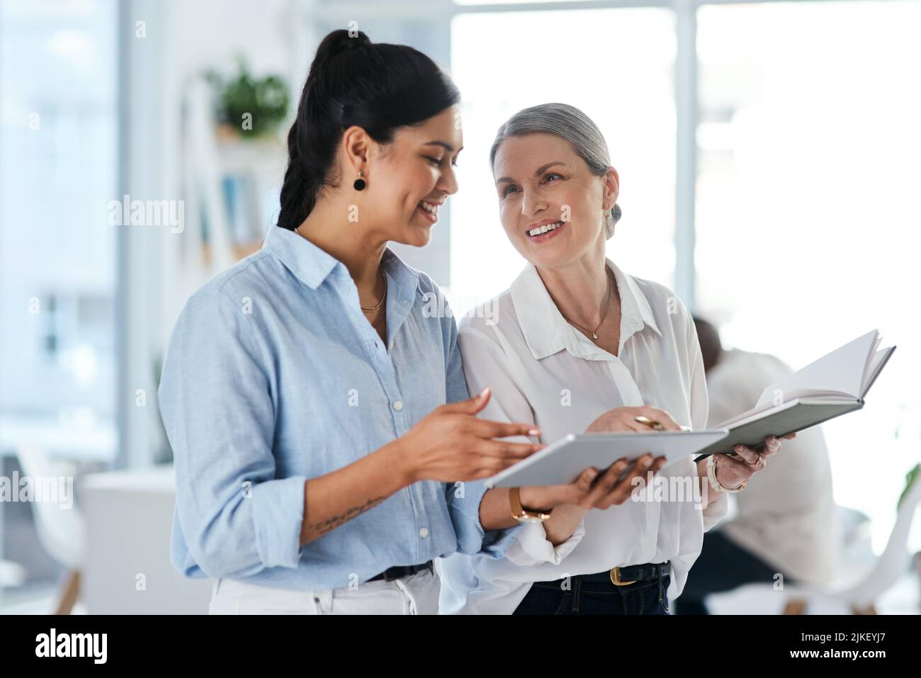 Collaborating on their master plan. two businesswomen using a digital ...