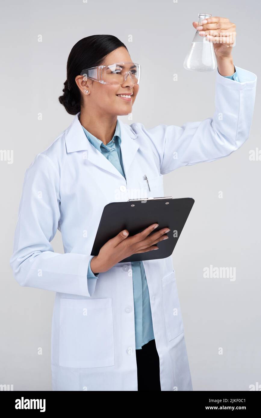 Examining the sample. an attractive young female scientist examining a ...
