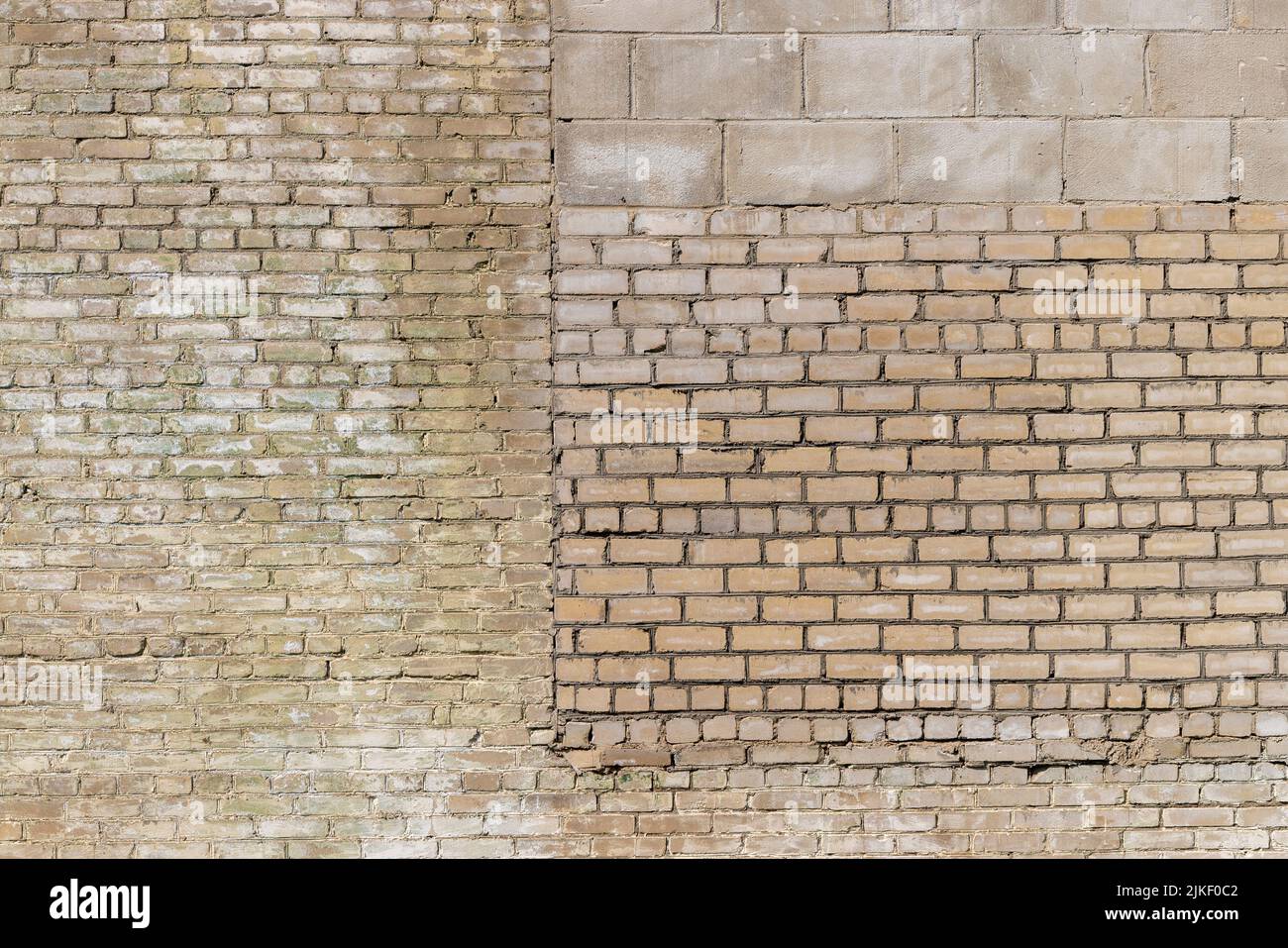 an old brick wall made of a large number of different types of bricks ...
