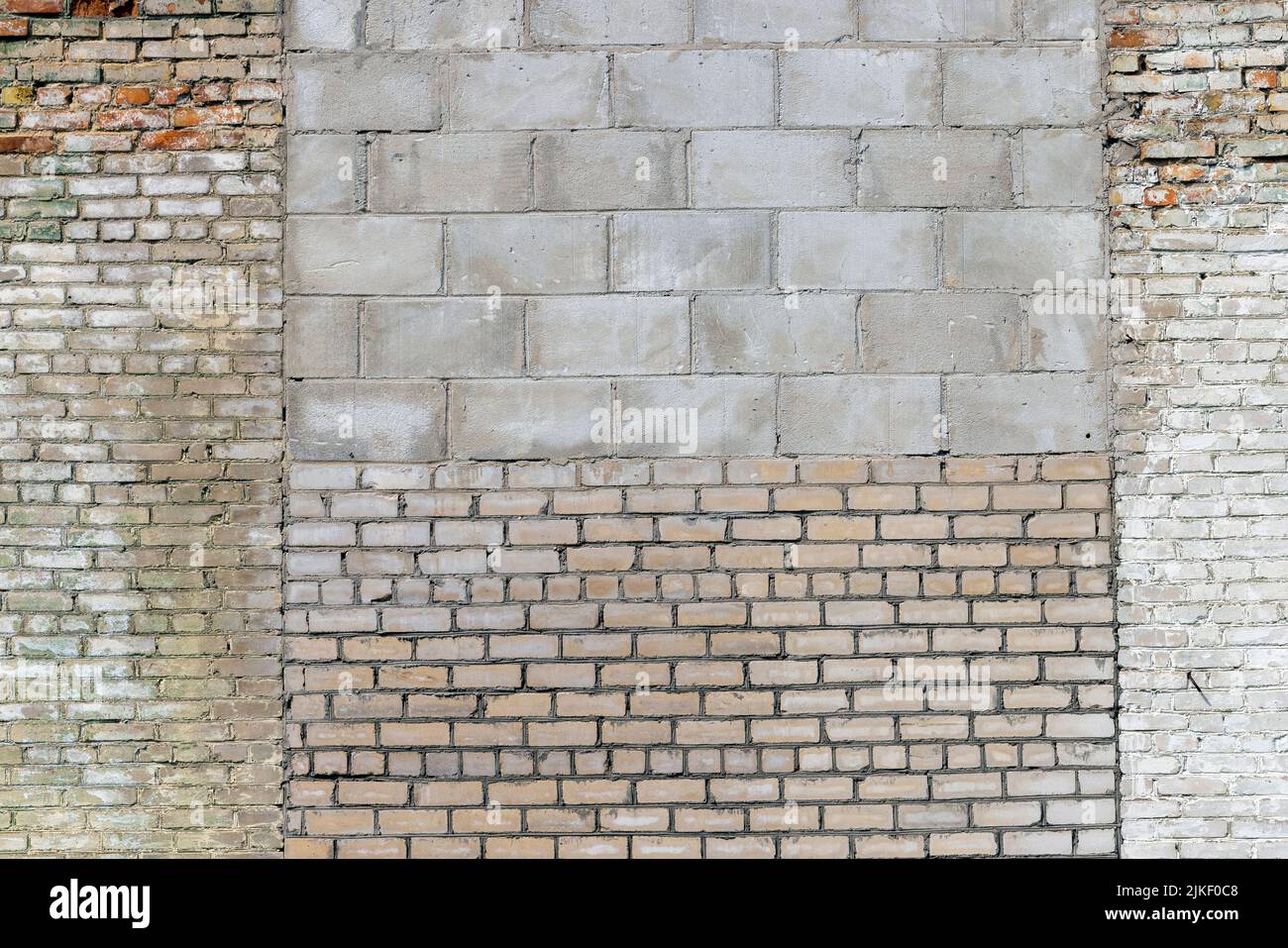 an old brick wall made of a large number of different types of bricks ...