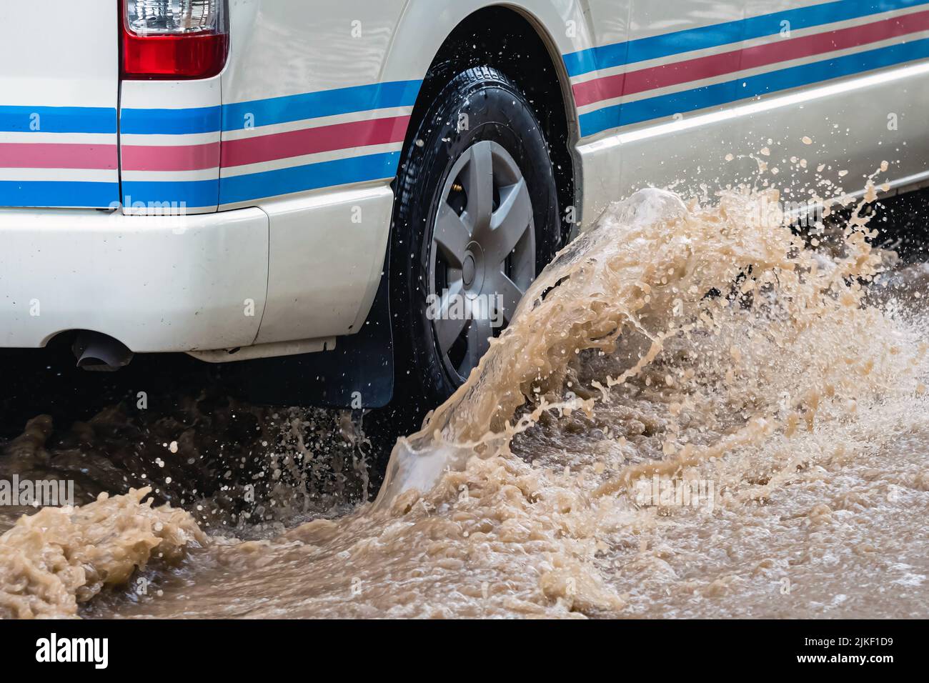 White van passing through flooded road. Driving car on flooded road ...