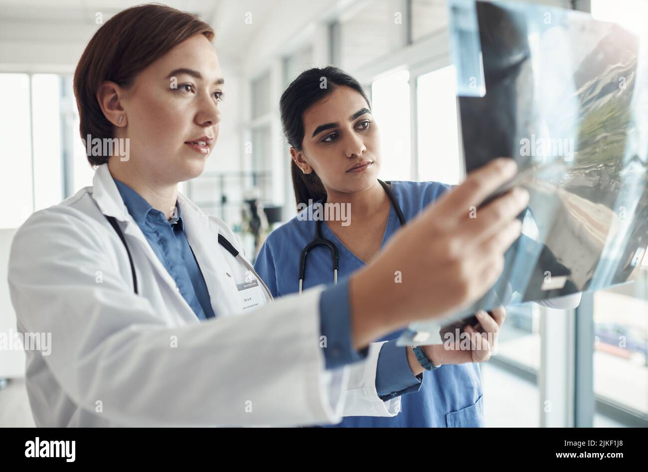 Saving one life at a time. two young doctors checking exrays in a ...